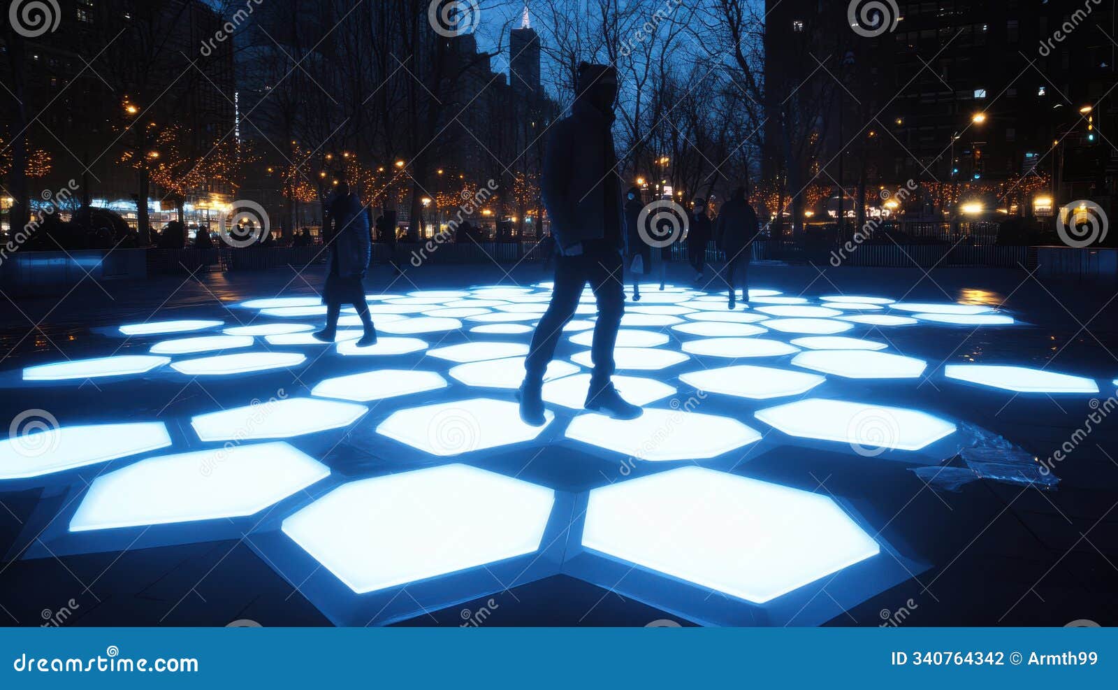 People Interacting with Illuminated Hexagonal Tiles in City Park at ...