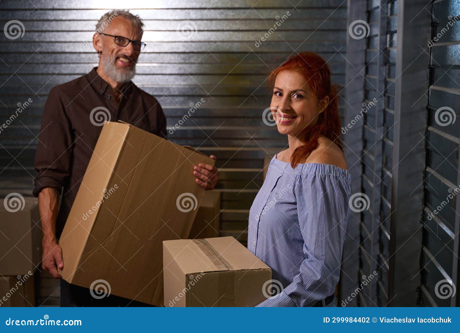People Loading Cardboard Boxes with Things into a Storage Container ...