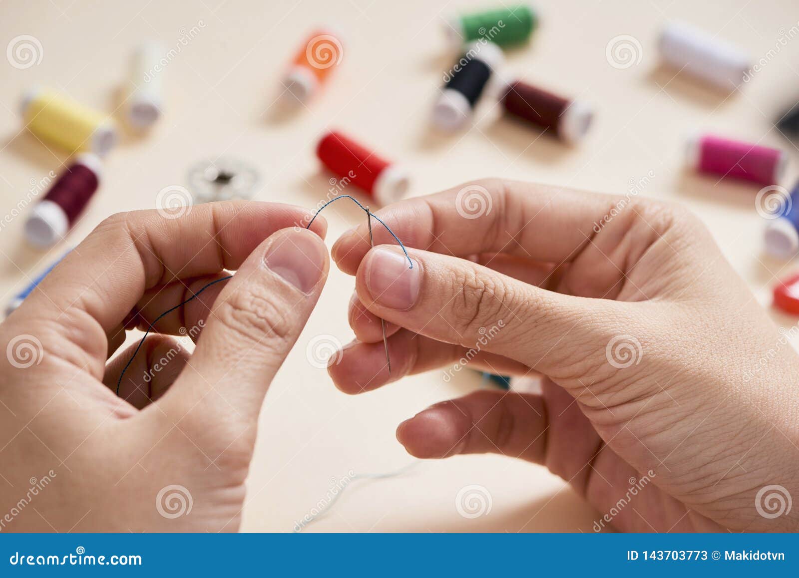 Hands Sewing With A Needle And Thread. Fingers Pulling Thread Into The ...