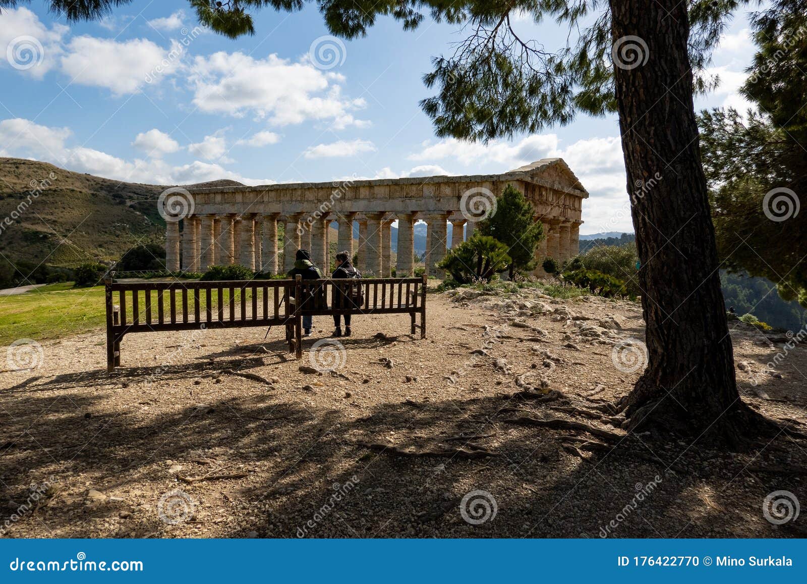 People Relaxing on a Bench in Front of the Ancient Doric Temple of ...
