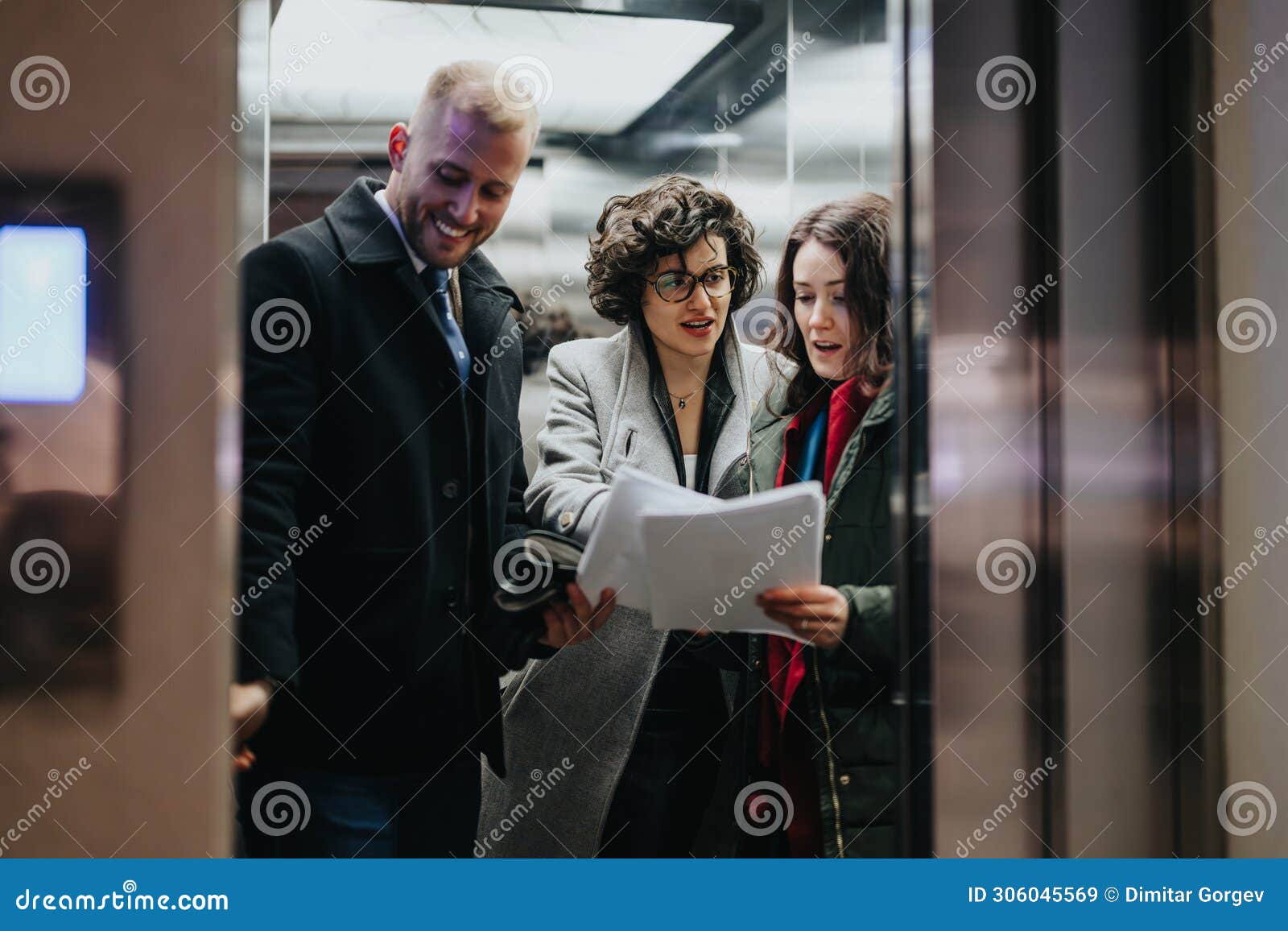 People Reviewing Documents Together in Modern Office Elevator. Stock ...