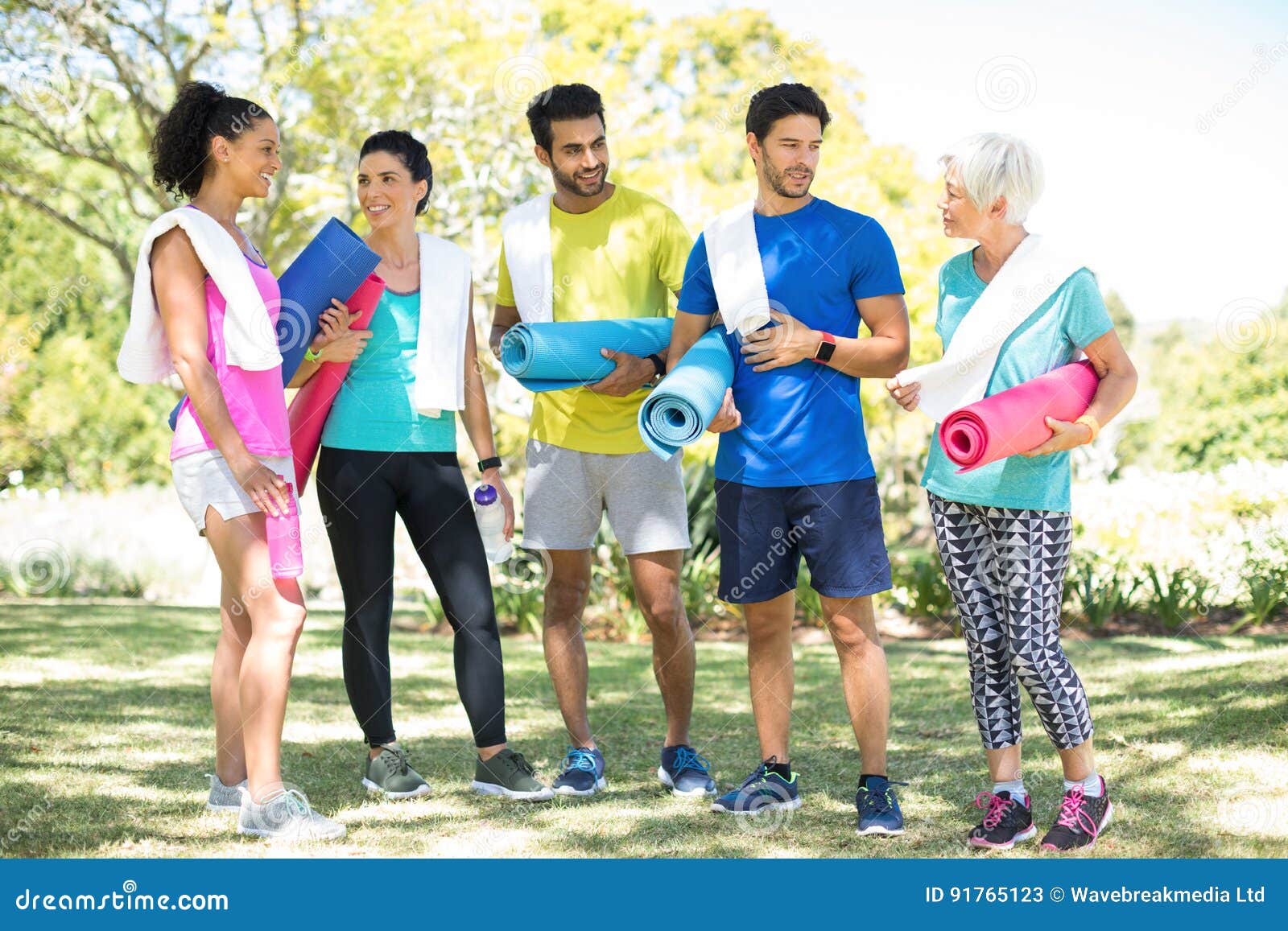 People with Rolled Exercise Mats Talking in the Park Stock Image ...