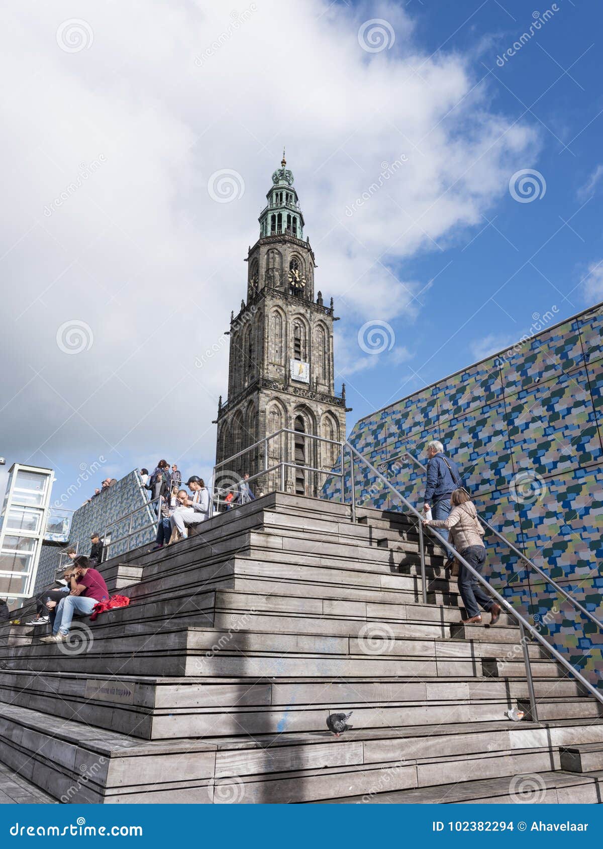 People Sit on Steps Near Central Square in Front of Martini Tower in ...