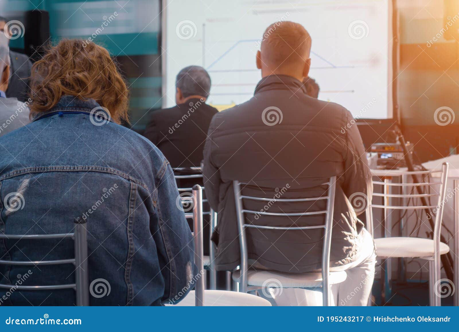 People are Sitting in Front of a Projector Screen at a Business ...