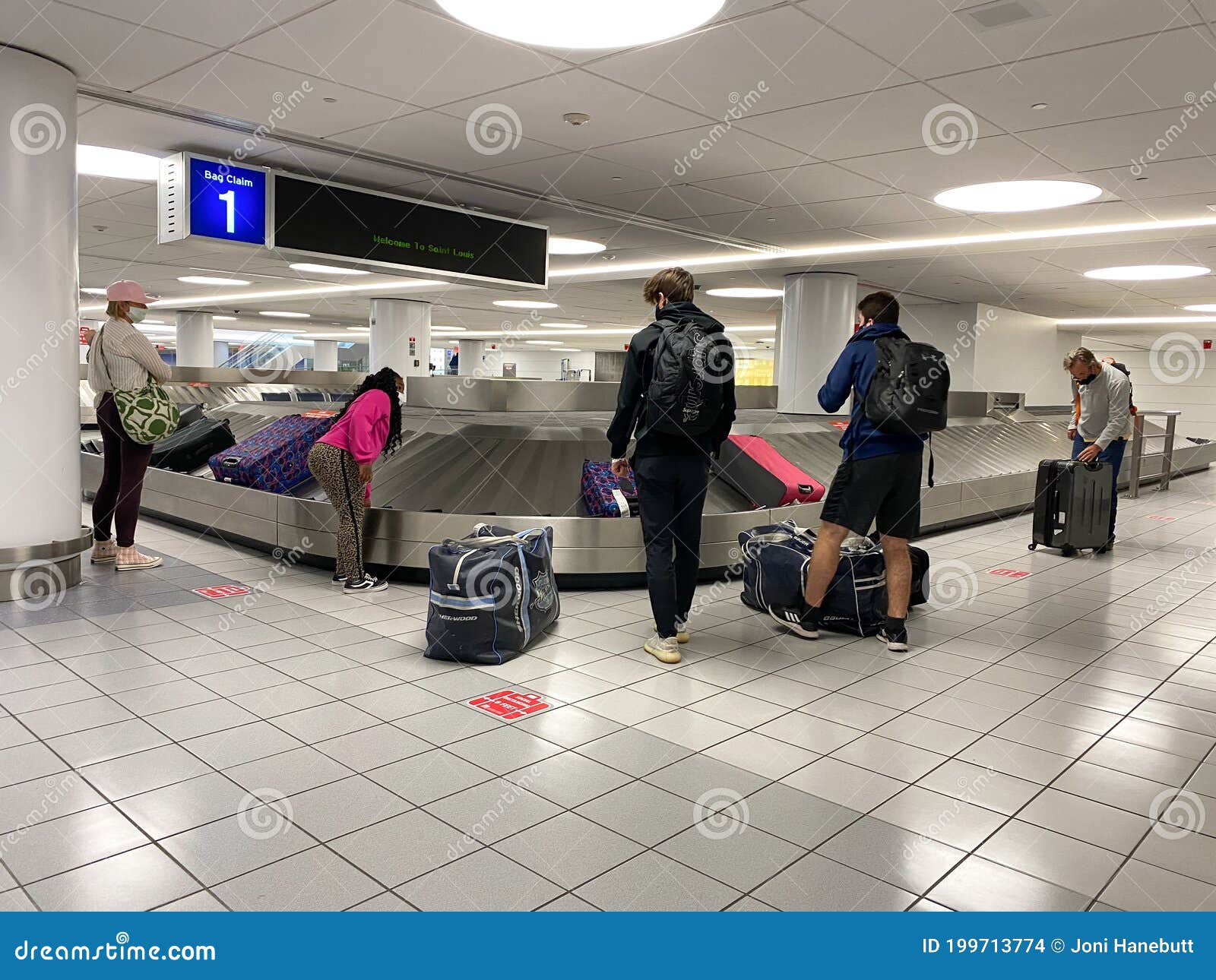 People Waiting at a Baggage Claim Carousel To Pick Up Their Luggage ... People Waiting at a Baggage Claim Carousel To Pick Up Their Luggage ...