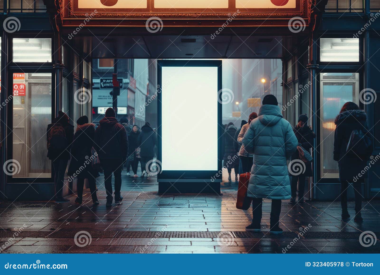People Walking Past a Glowing Digital Advertising Board at Night Stock ...