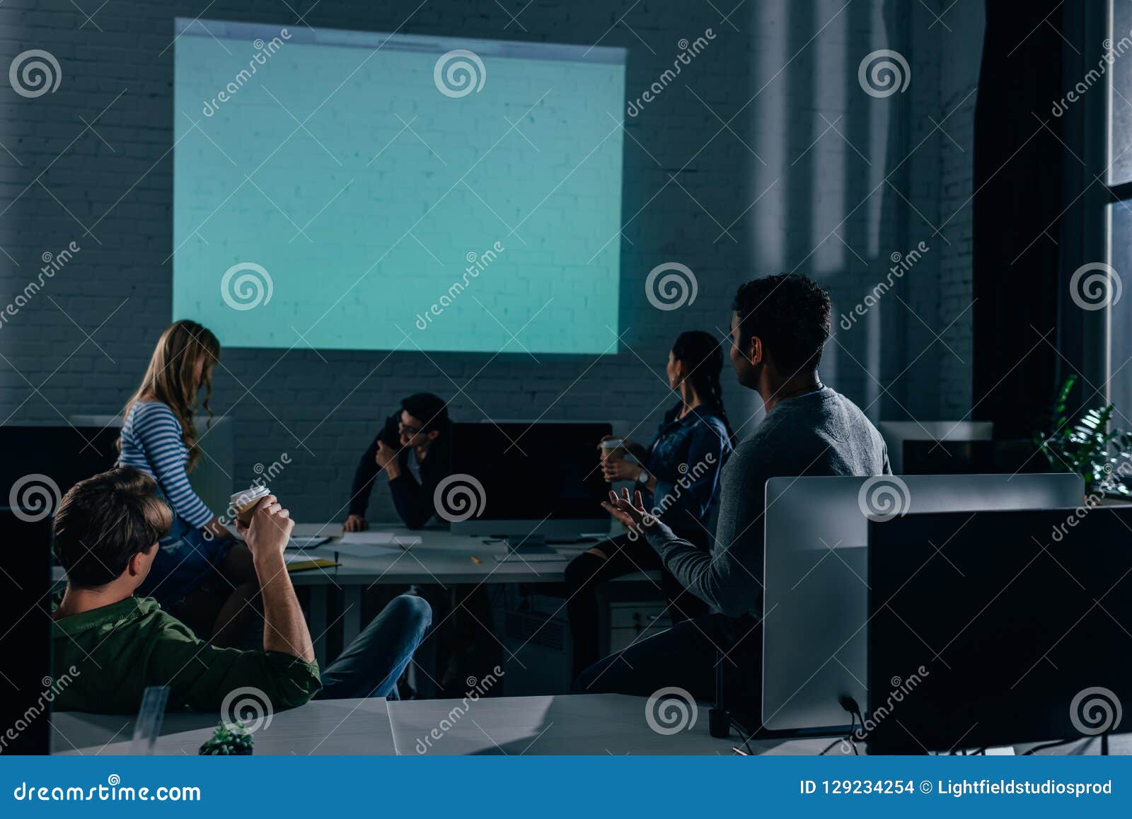 People Watching Presentation in Office at Nighttime Stock Photo - Image ...