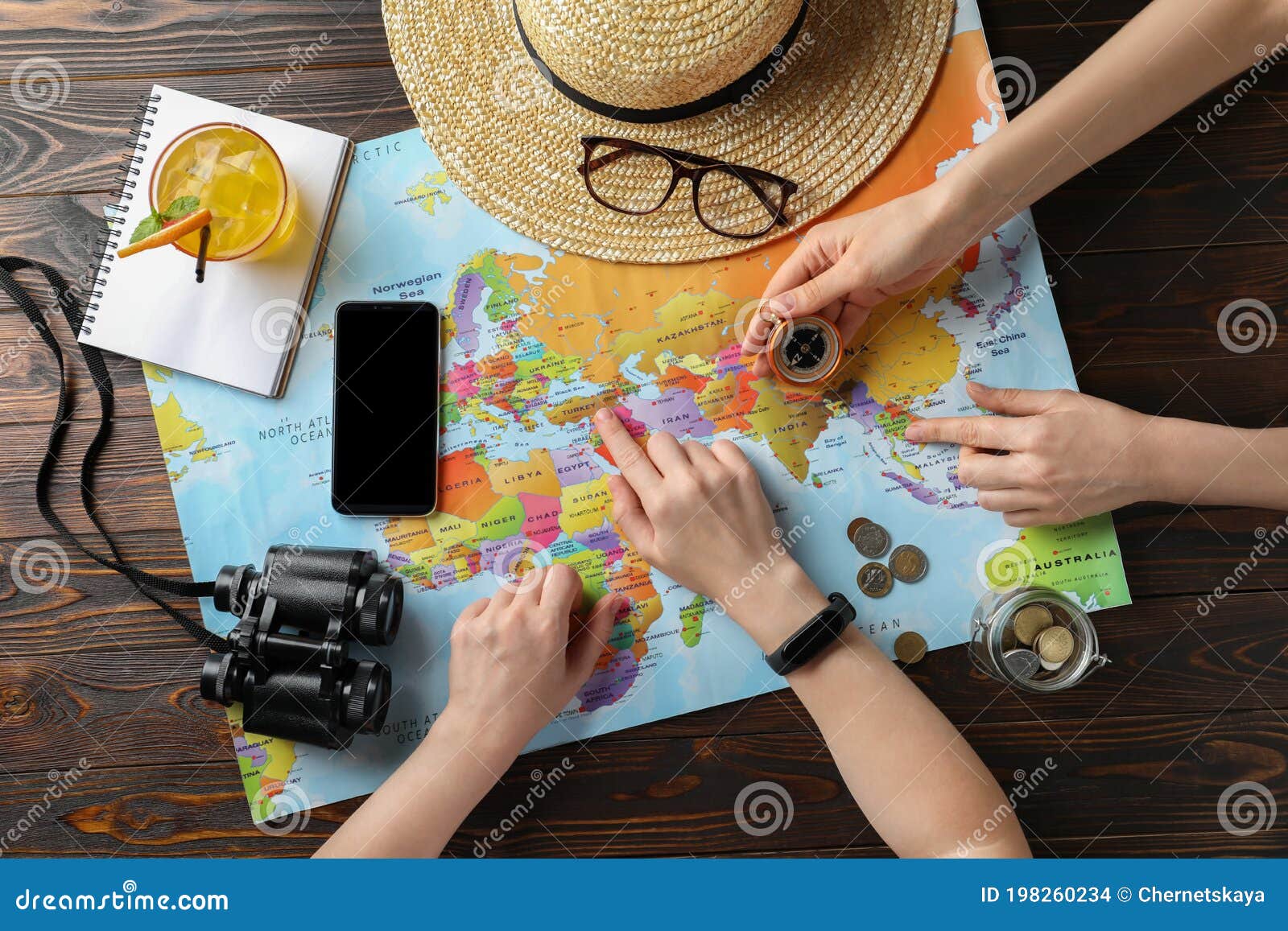 People with World Map and Accessories at Table, Top View. Travel during ...