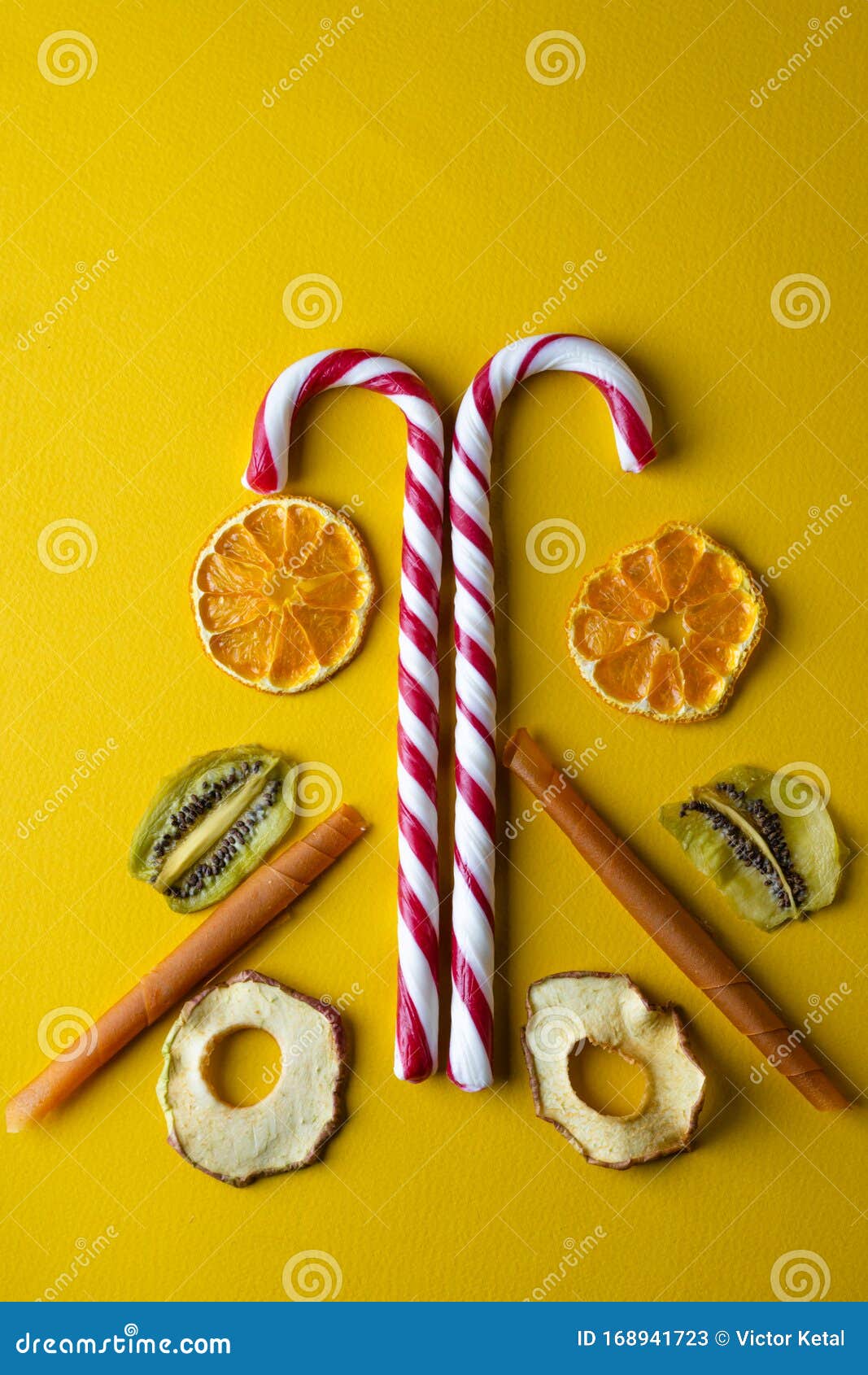 Peppermint Candy Canes with Dried Fruits on a Yellow Background Stock ...