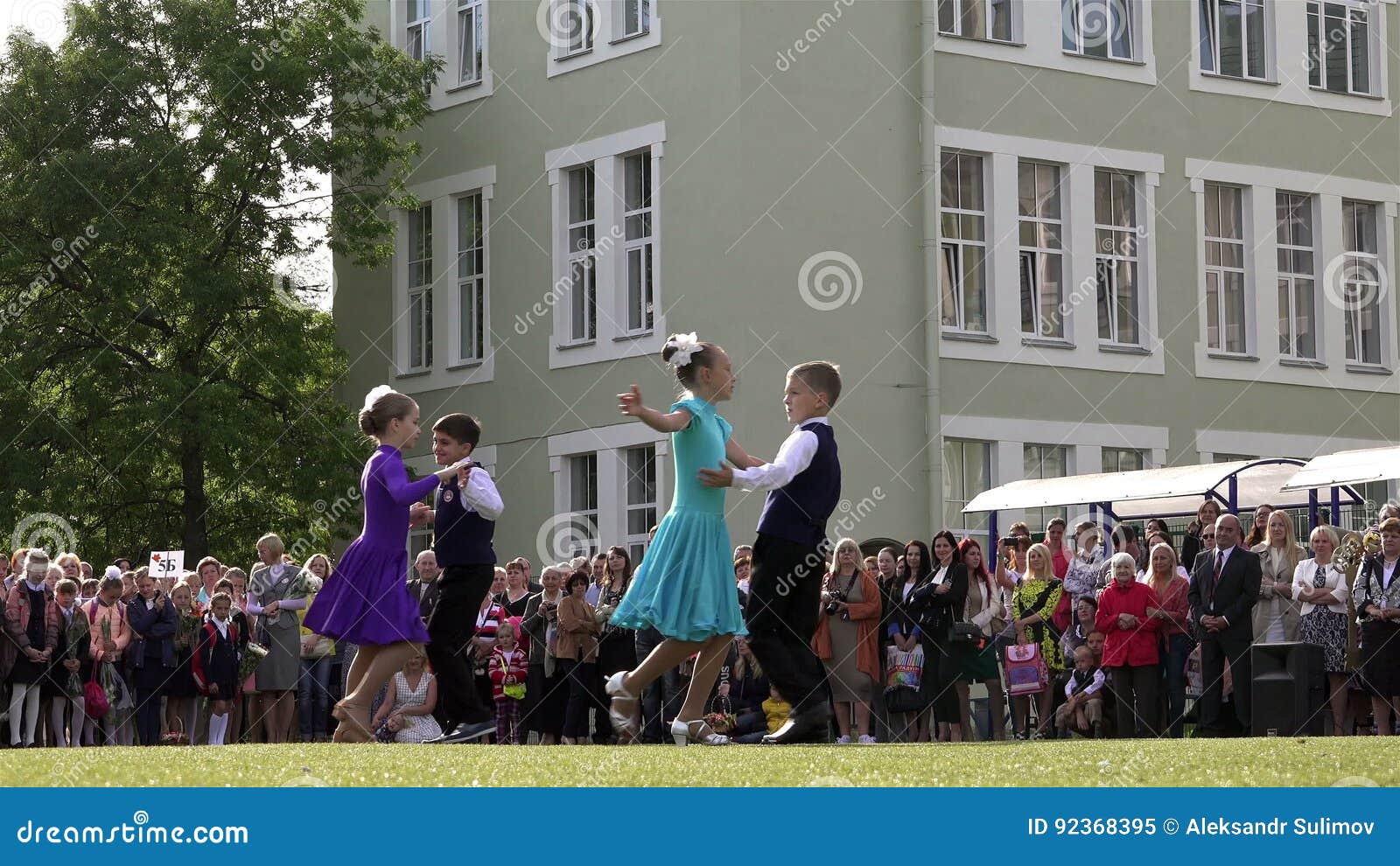Performance of Two School of Dancing Couples on a Green Grass in Front ...