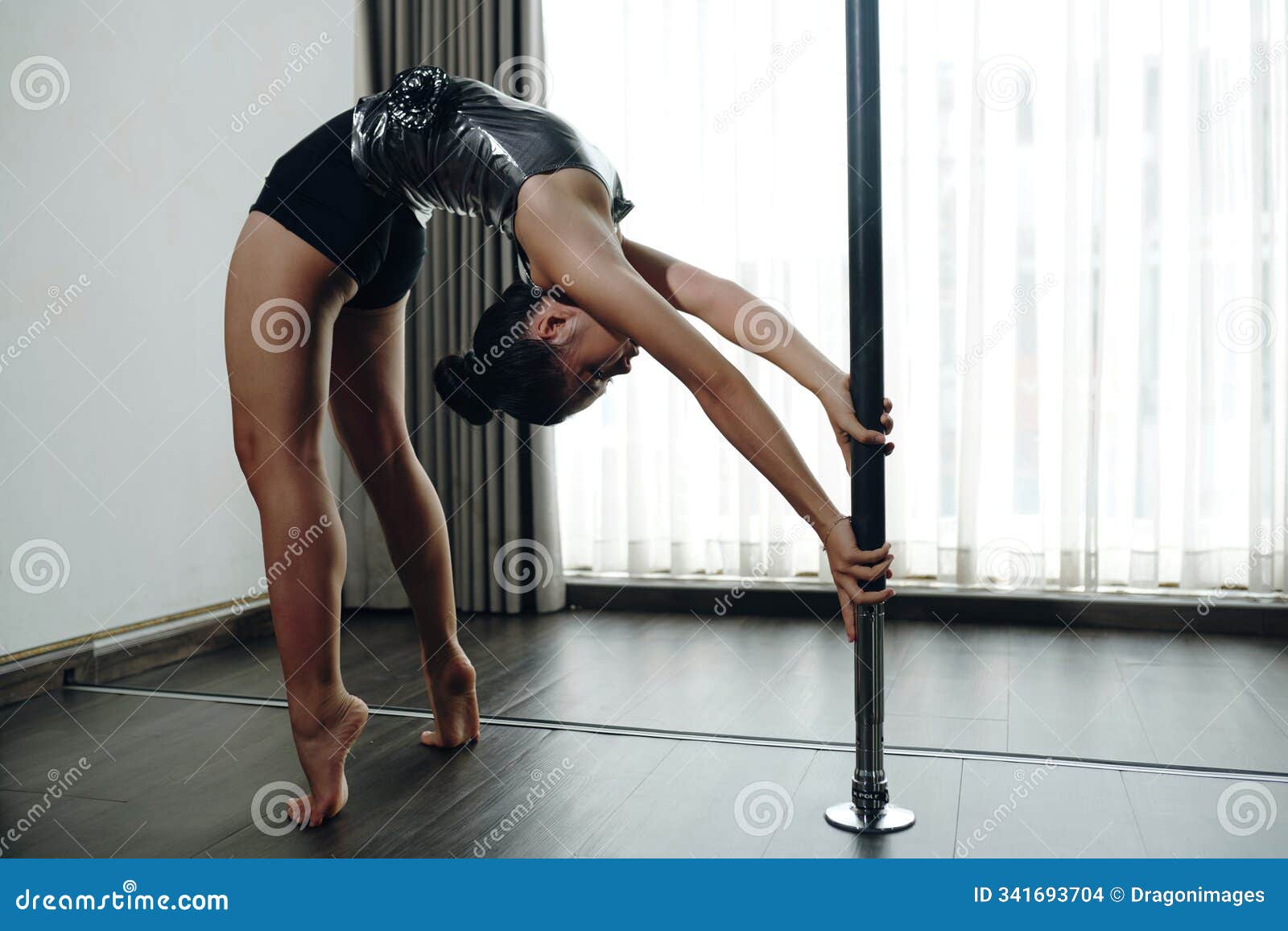 Performing Advanced Pole Dance Stretch by Window Stock Photo - Image of pole, expression: 341693704