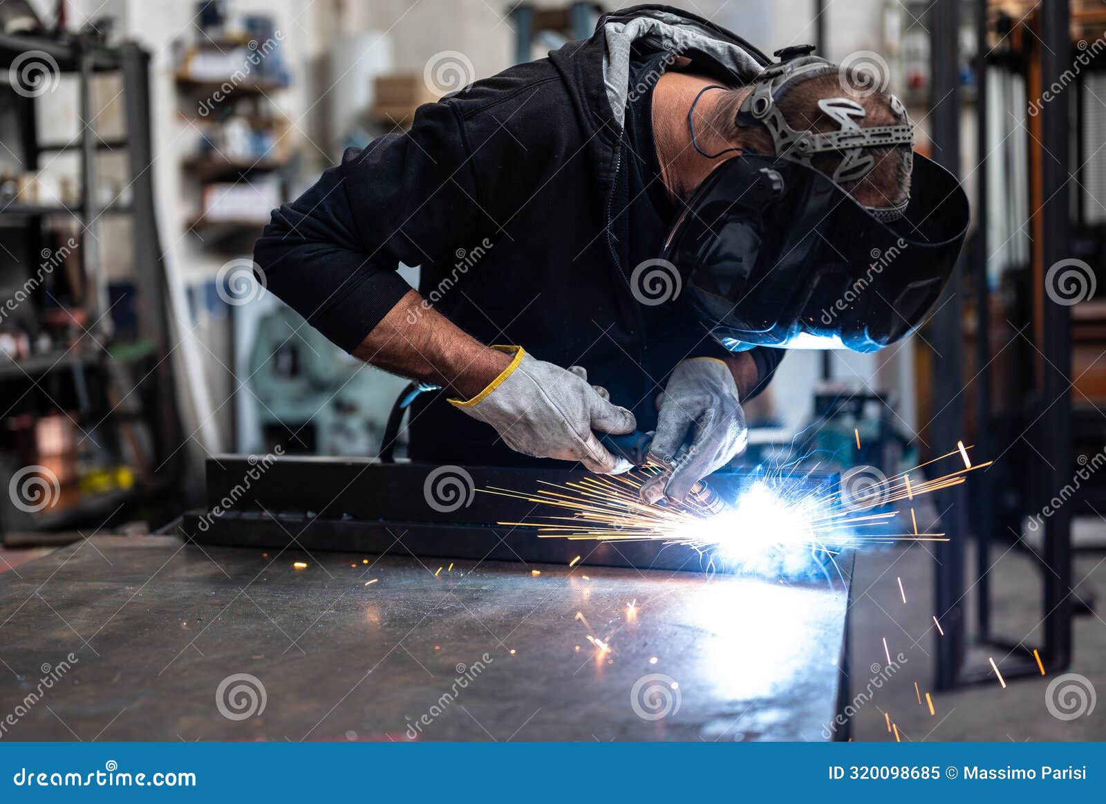 Performing a Weld: the Man in the Welding Mask is Positioned with the ...