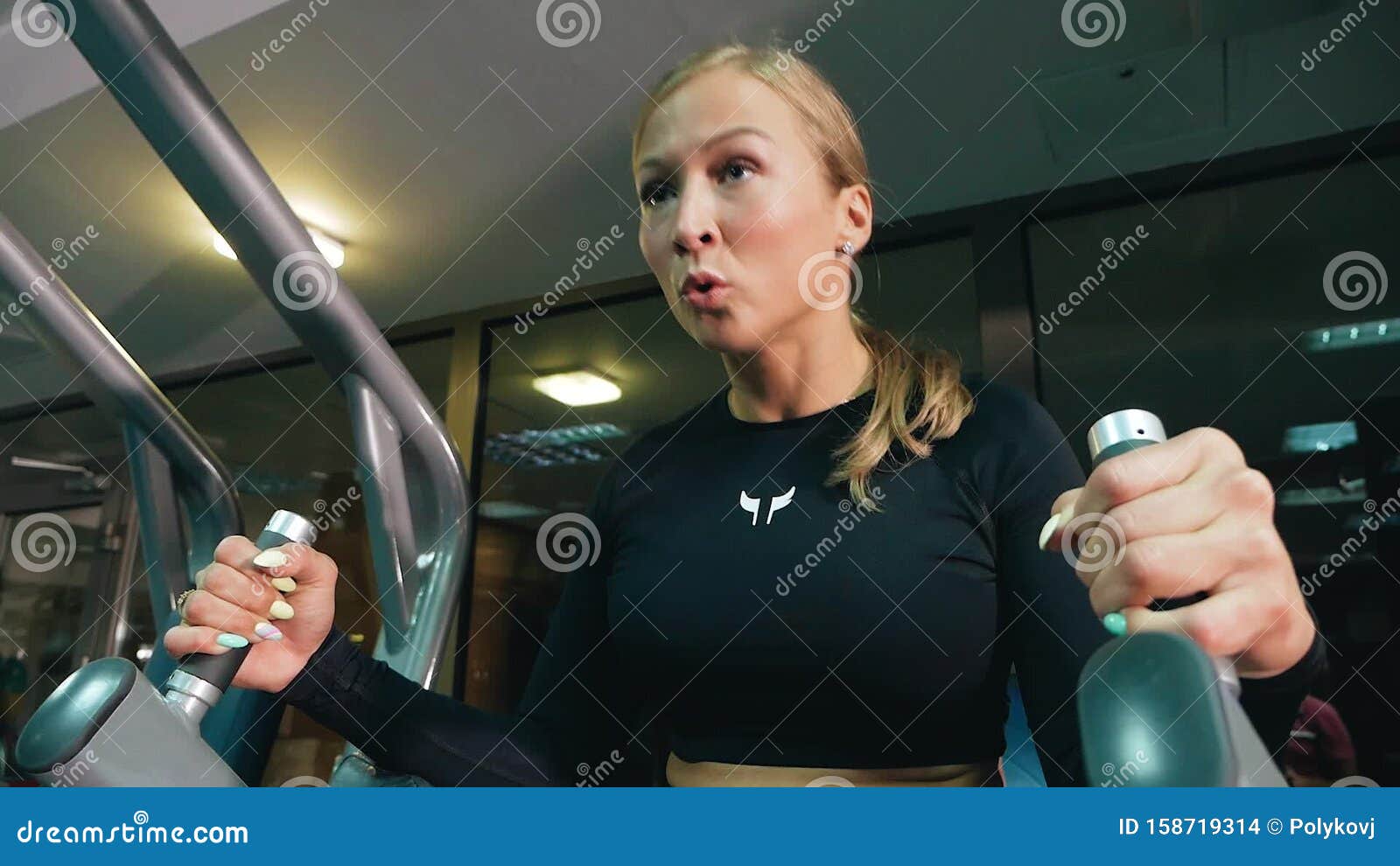 She Performs Exercises on the Simulator. Close-up of Her Face. she Was ...
