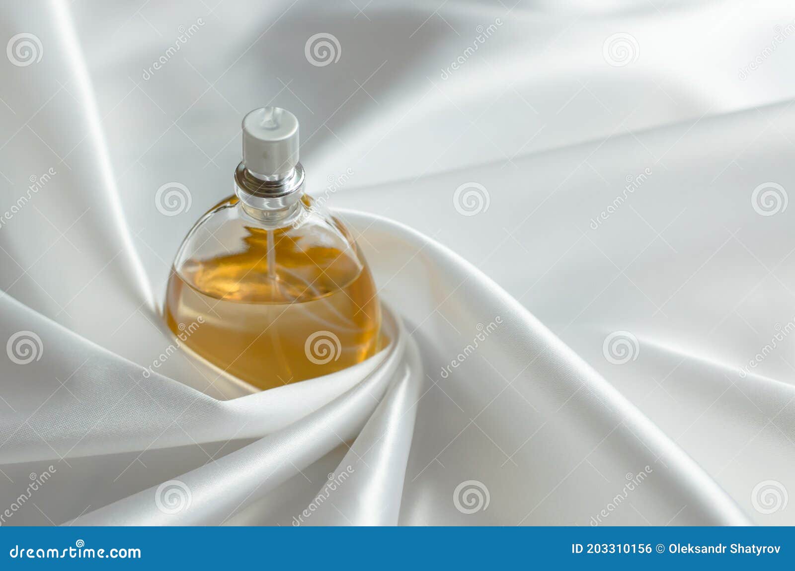 Perfume in Silk Fabric. a Bottle of Women S Perfume Wrapped in Wavy ...