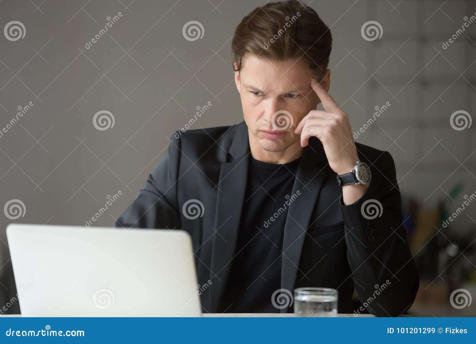 Perplexed Young Businessman Looking at Laptop Screen at Workplac Stock ...