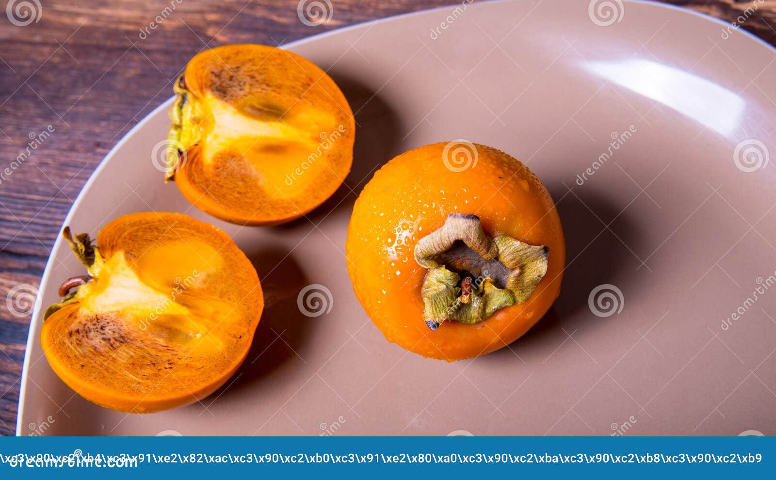 Persimmon Cut in Half and Whole Persimmon on a Plate on a Wooden Table ...