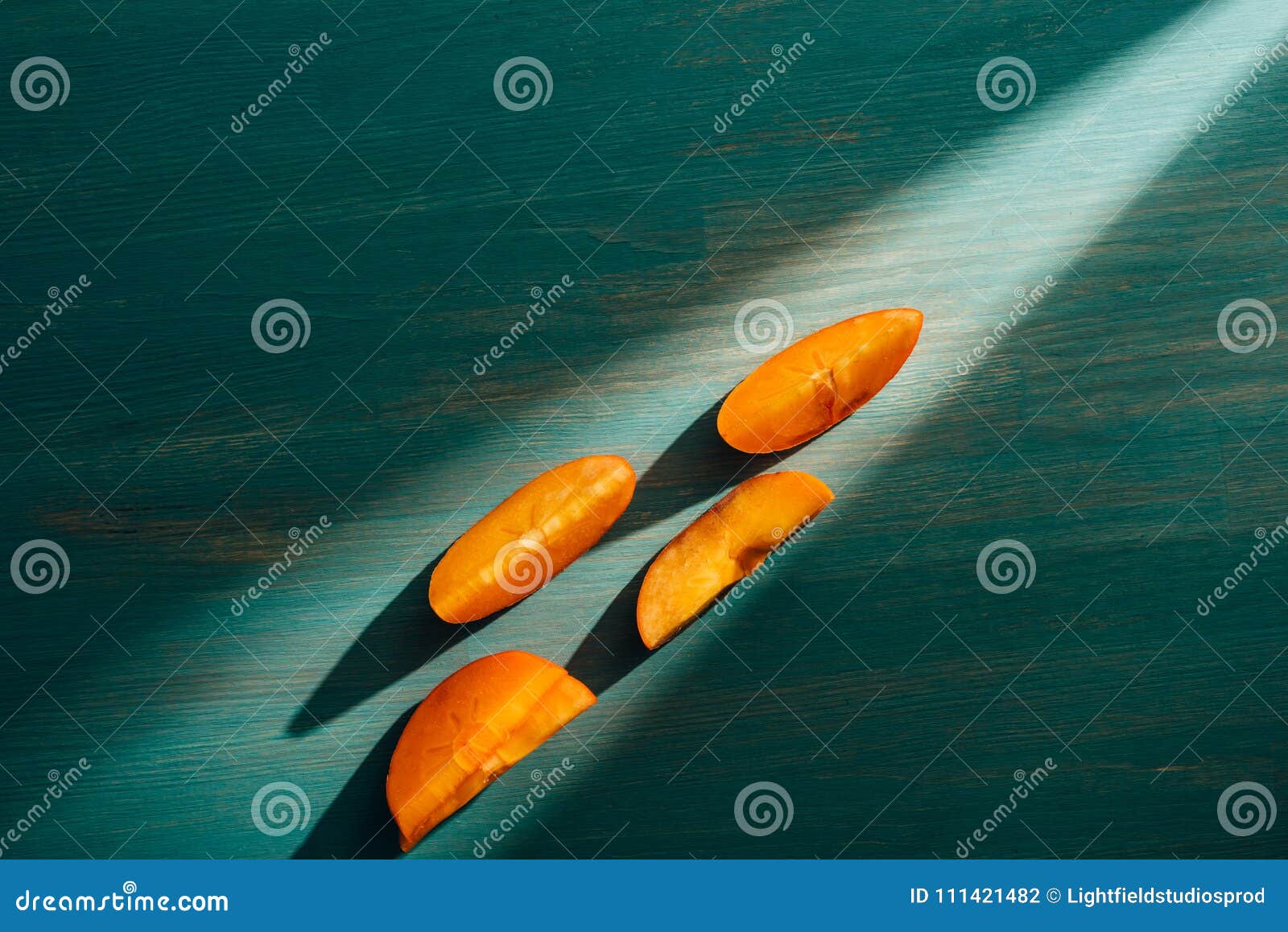Persimmon Persimmon Pieces on Table with Light and Shadow Stock Photo ...