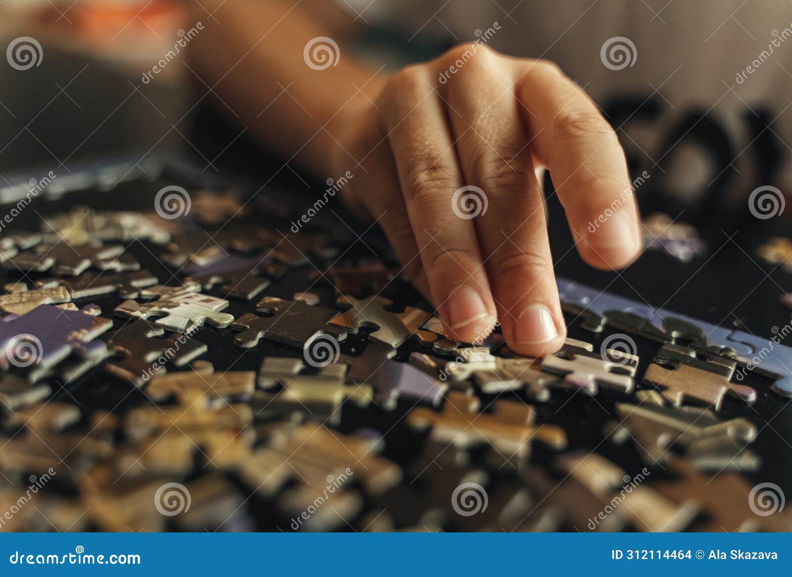 A Person is Concentrating on Placing a Puzzle Piece into the Correct ...