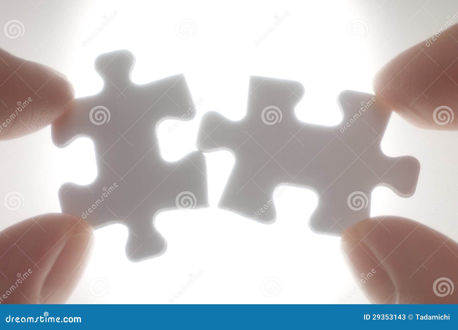 A Person Connecting Puzzle Pieces Against the Light. Stock Image ...