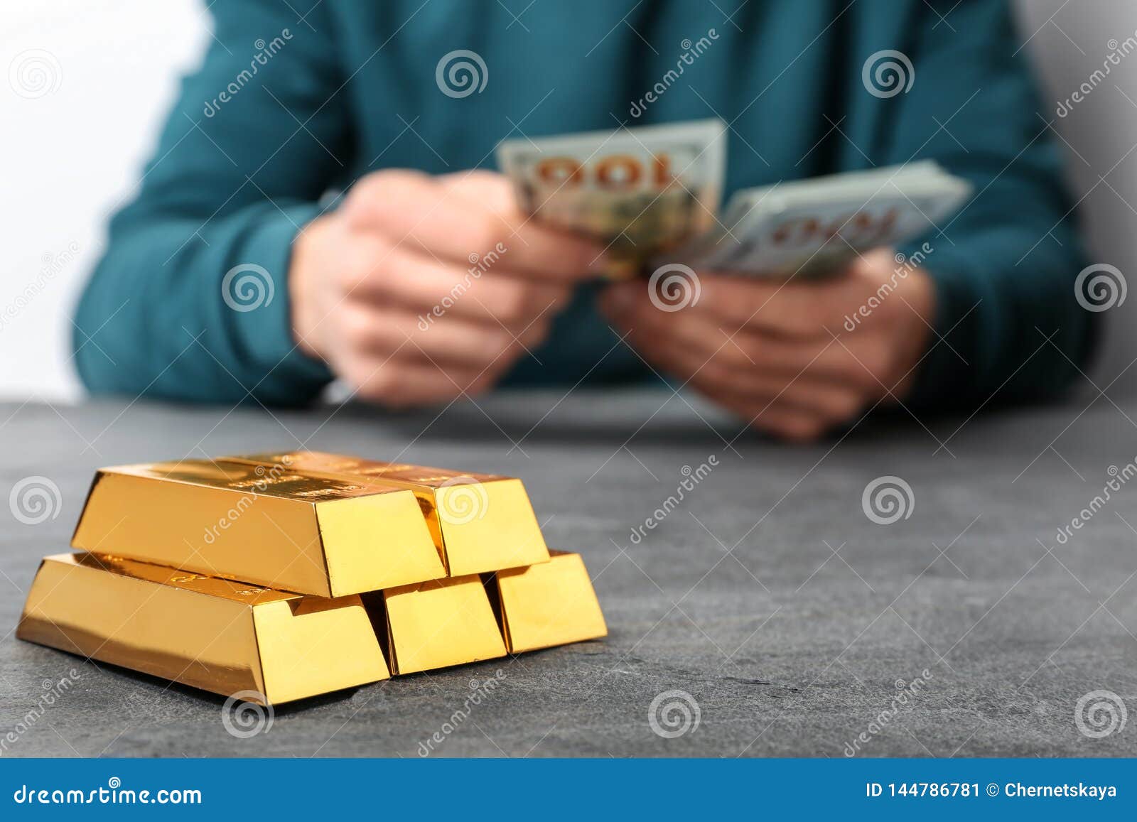Person Counting Money at Table, Focus on Stacked Gold Bars. Stock Image ...