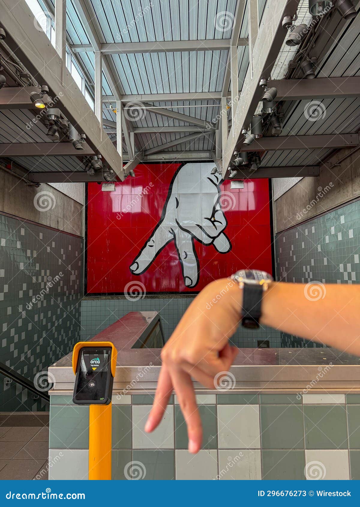 Person Gesturing Towards a Round Clock Face Mounted on a White-tiled ...