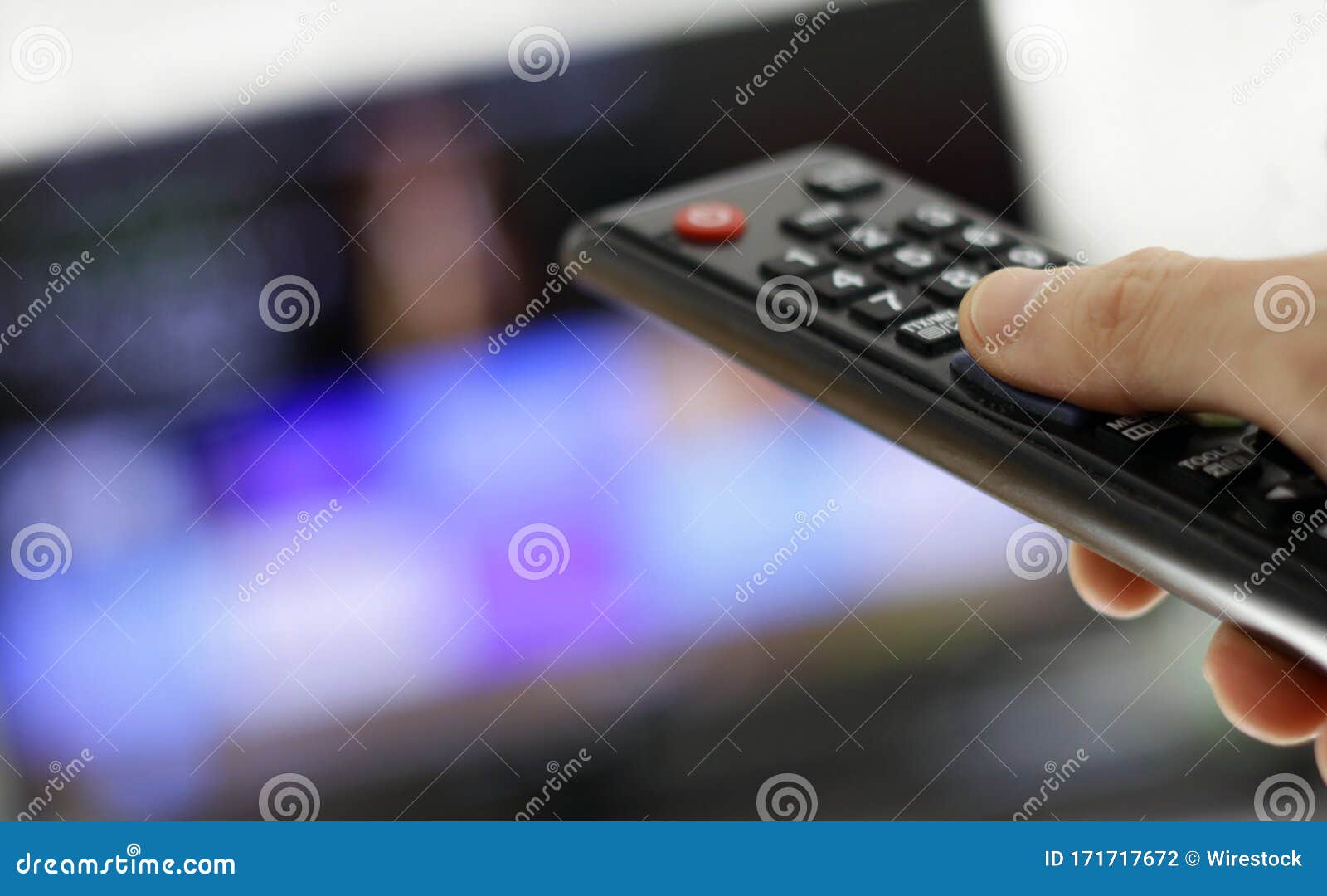 Person Holding a Black Remote Control in Front of the TV Stock Photo ...