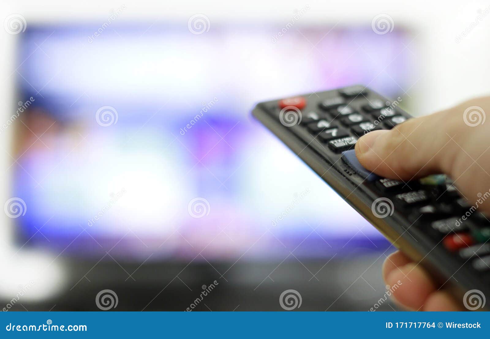 Person Holding a Black Remote Control in Front of the TV Stock Photo ...