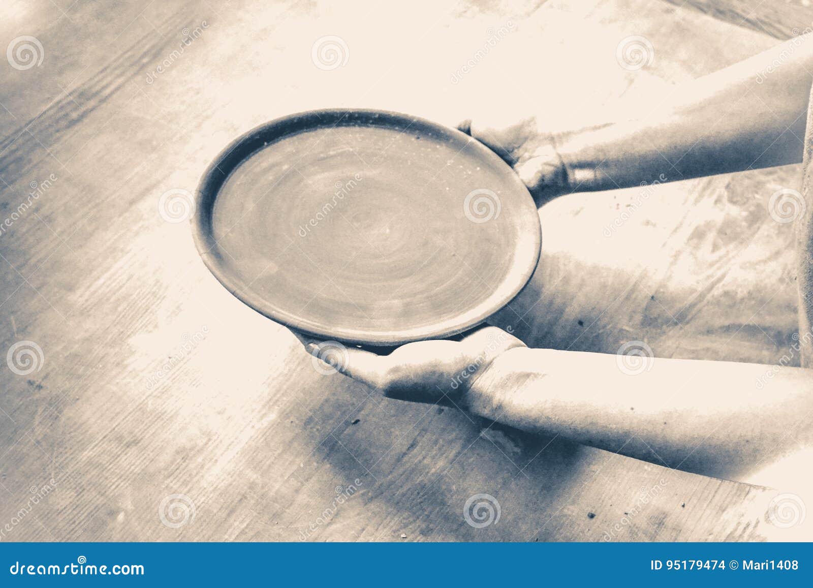 Person Holding an Empty Plate on a Wooden Table Stock Photo - Image of ...