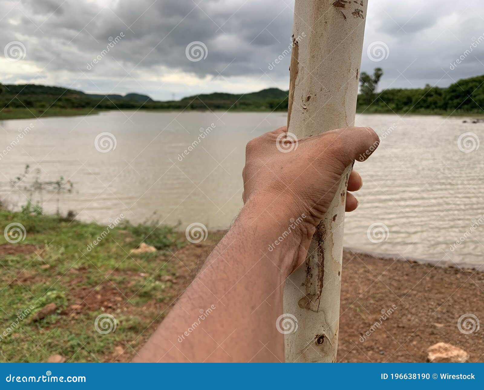 Person Holding a Stick in Front of the Lake Stock Photo - Image of ...