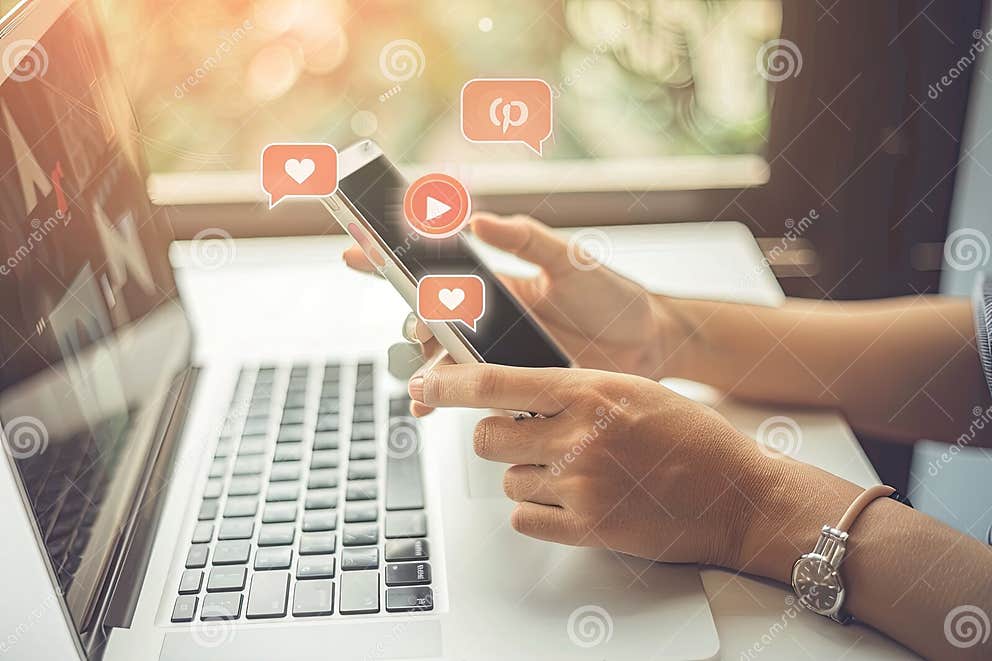 A Person is Multitasking with a Laptop and Cell Phone in an Office ...