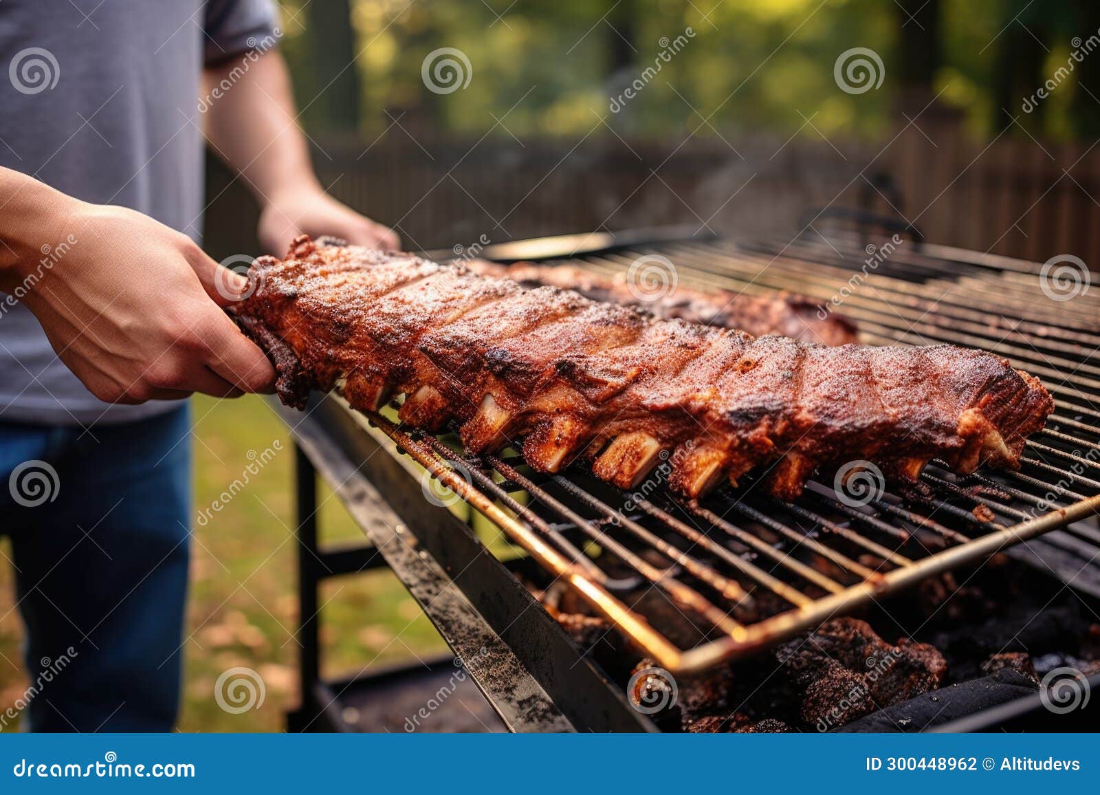 A Person Pulling a Rack of Cooked Ribs Off the Grill Stock Photo ...