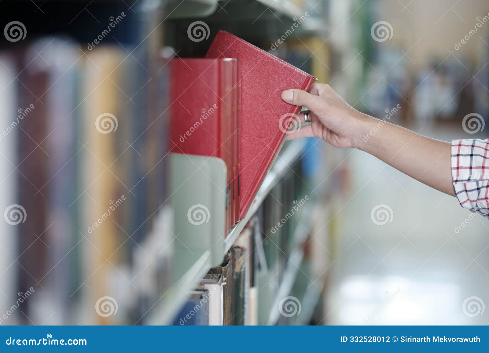 A Person is Reaching for a Red Book on a Library Shelf Stock Photo ...