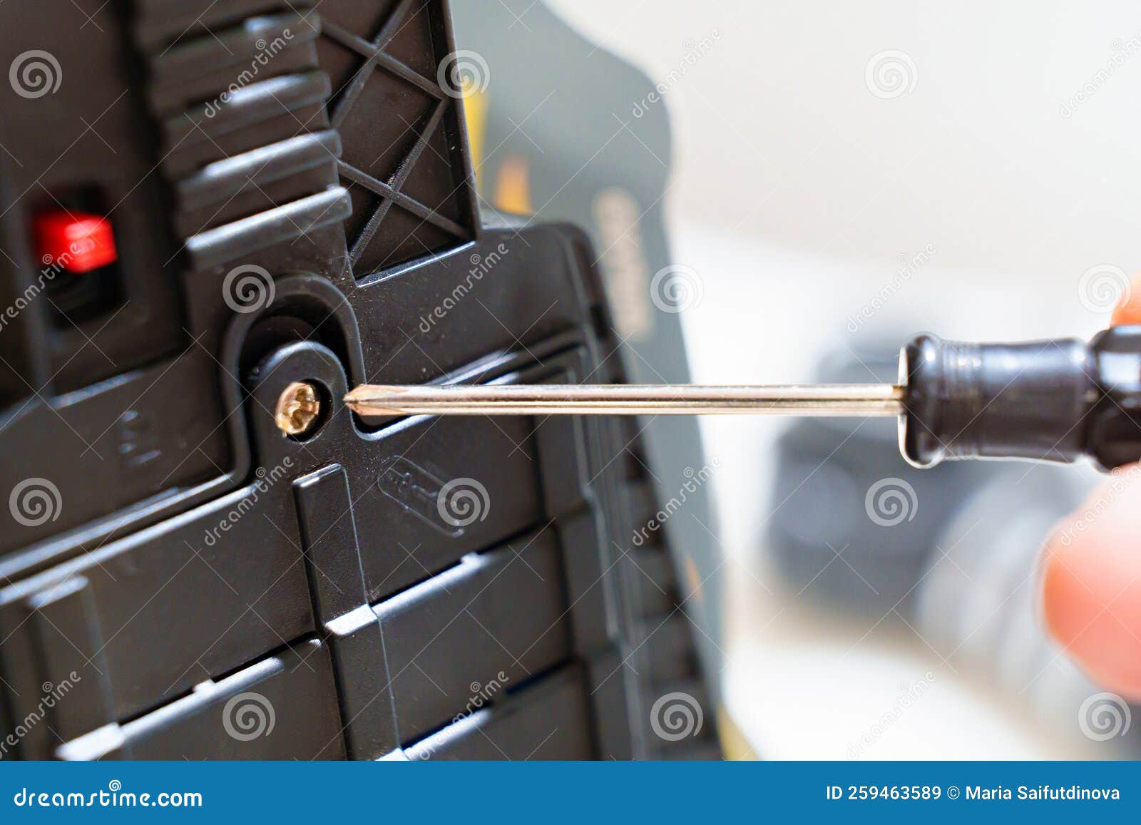 A Person with a Screwdriver Opens the Compartment for Batteries and ...