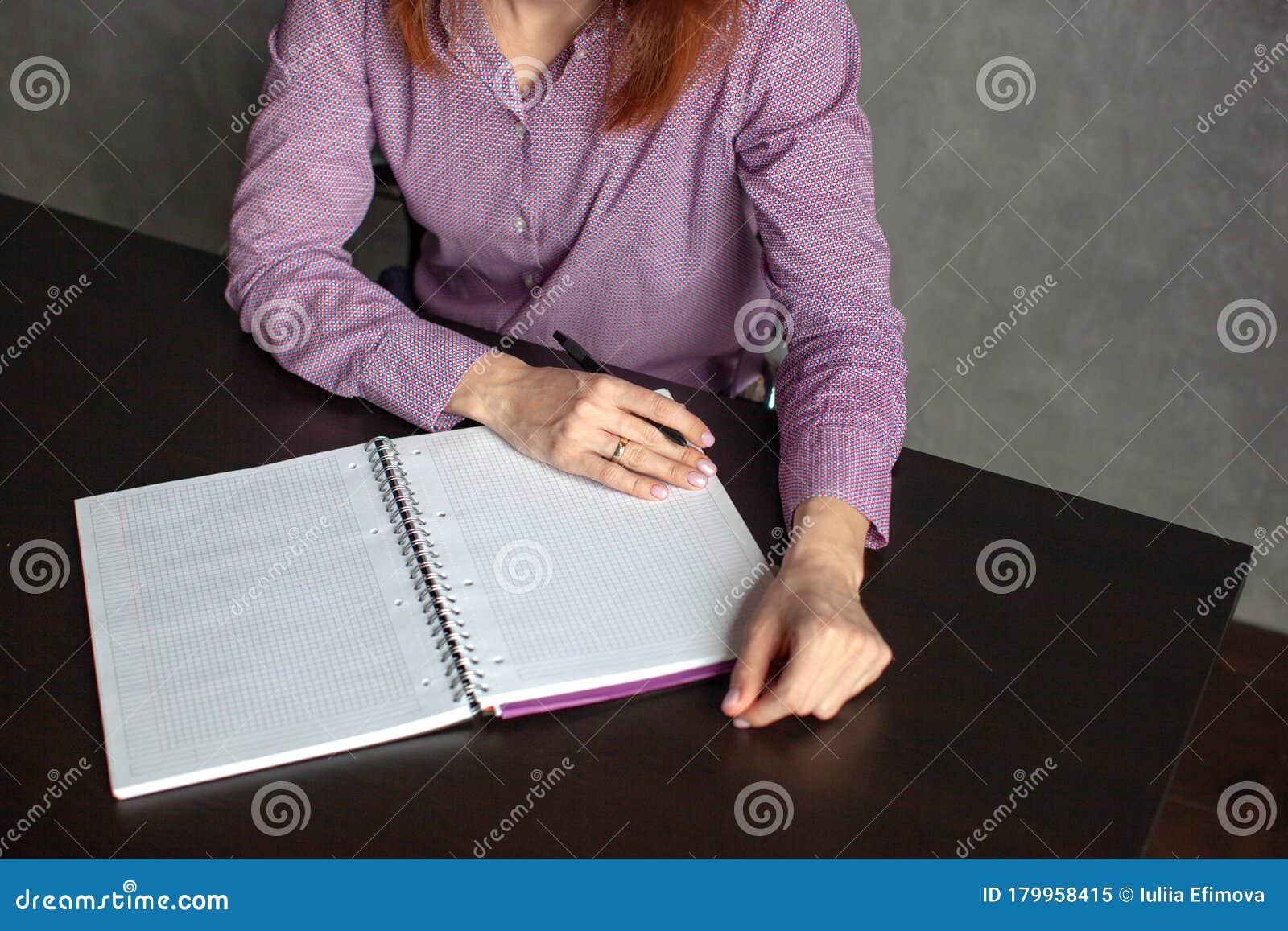 A Person Sitting at a Table Using a Laptop Stock Image - Image of book ...