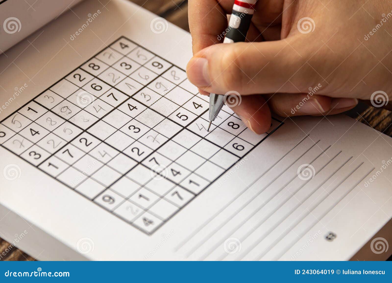 A Person Solving a Sudoku Puzzle on a Wooden Table Stock Image - Image ... A Person Solving a Sudoku Puzzle on a Wooden Table Stock Image - Image ...