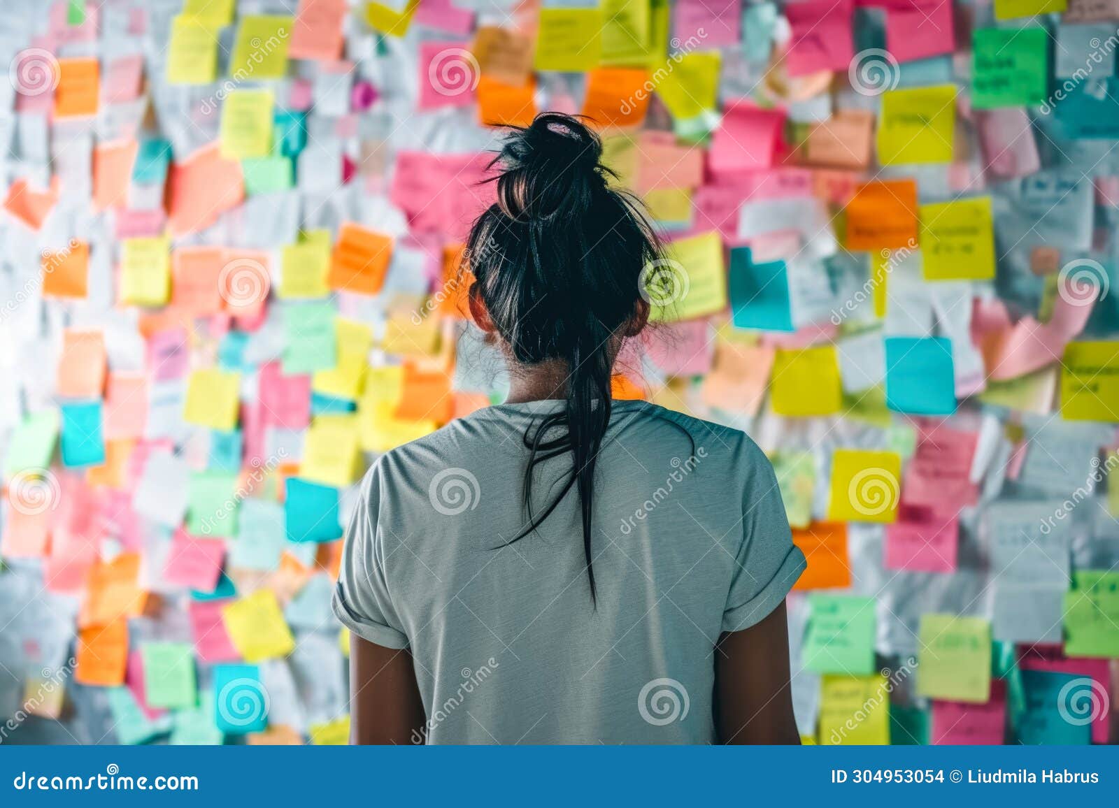Person Standing In Front Of A Wall Covered In Sticky Notes Organizing