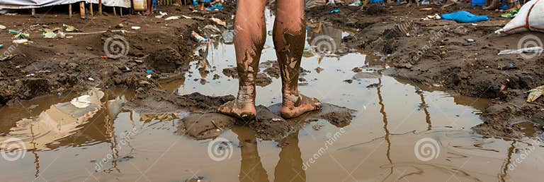 Person Standing Gracefully in a Muddy Puddle, Surrounded by Splashes of ...