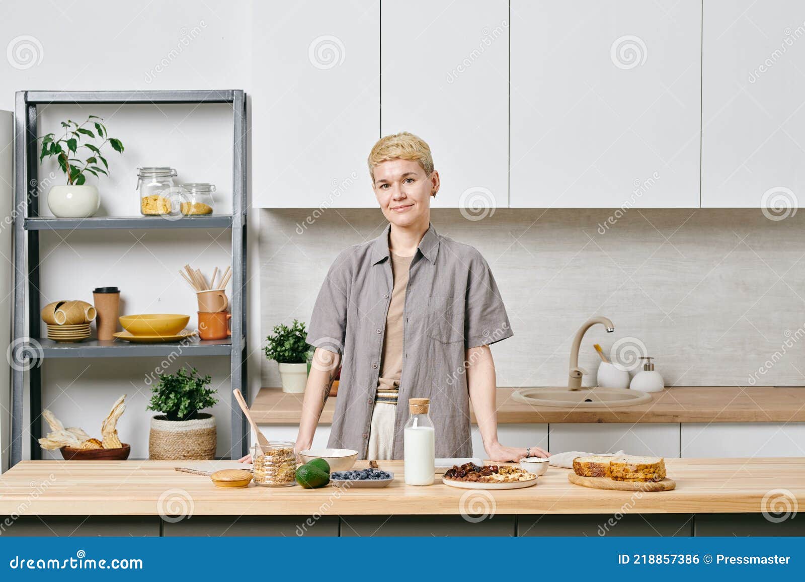 A Person Standing in a Kitchen in Front of Large Wooden Table Stock ...