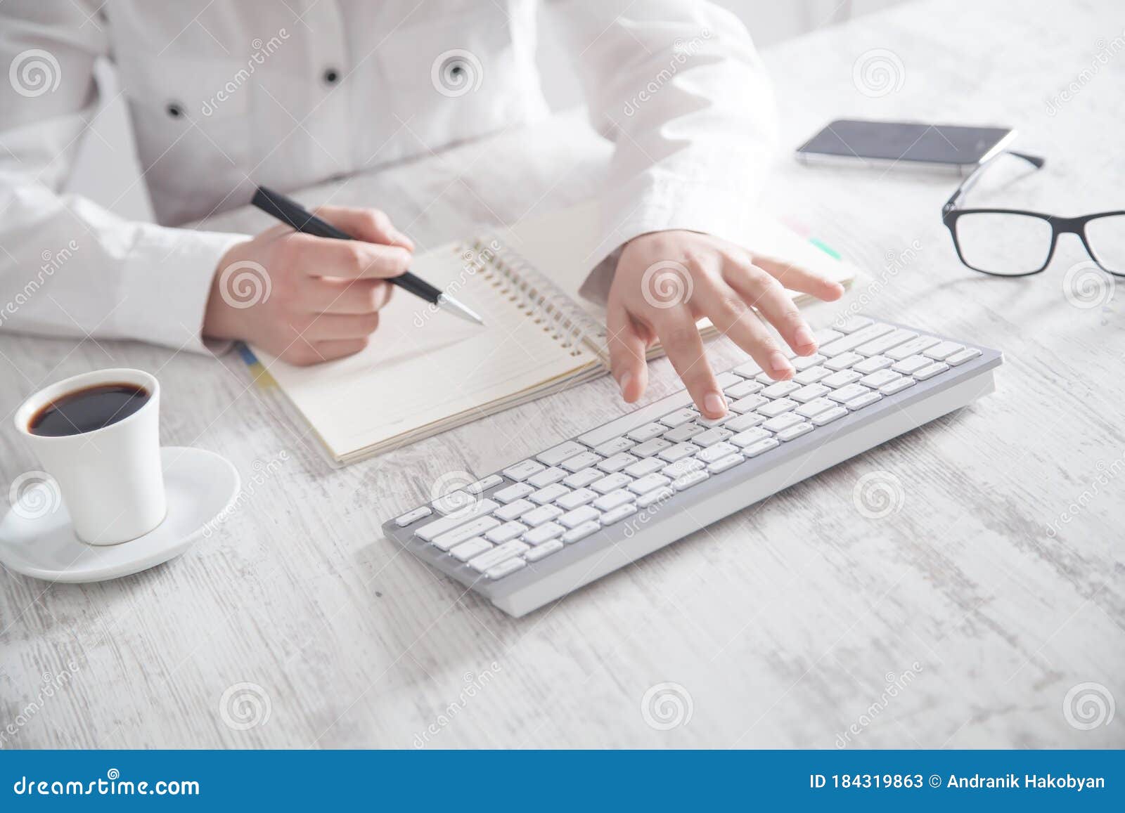 Person Typing in Keyboard and Writing on Notepad Stock Image - Image of ...
