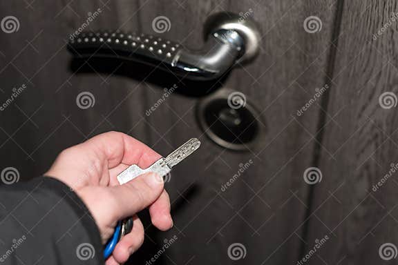 Person Unlocking a Modern Door Using a Key, Signifying Security and ...