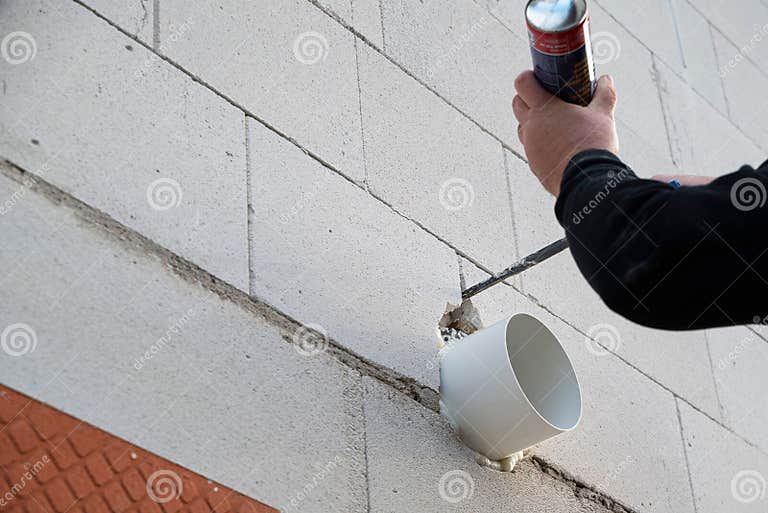 Person Using a Hammer To Fix an Object that is Hanging from the Side of ...