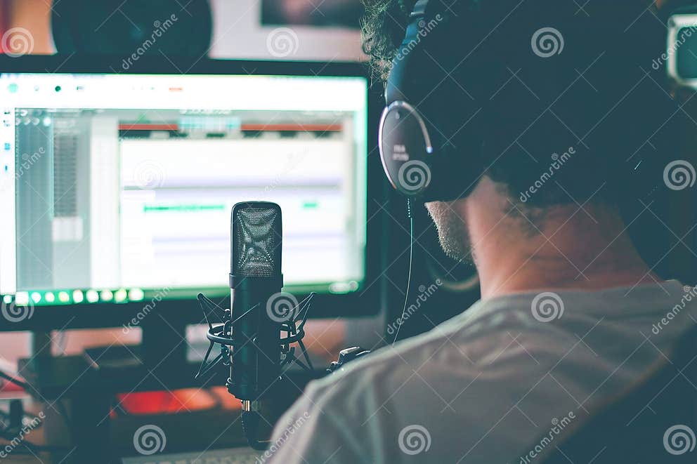 A Person Using a Microphone in a Workspace To Record Audio, Creating ...