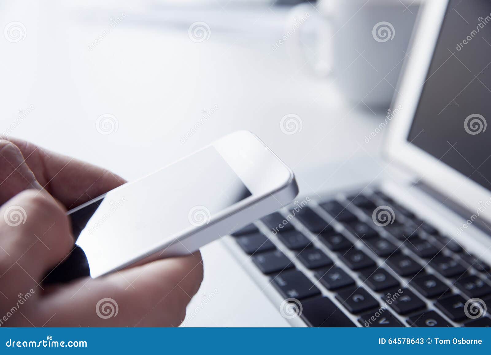 Person Using Phone while Working on a Laptop Stock Image - Image of ...
