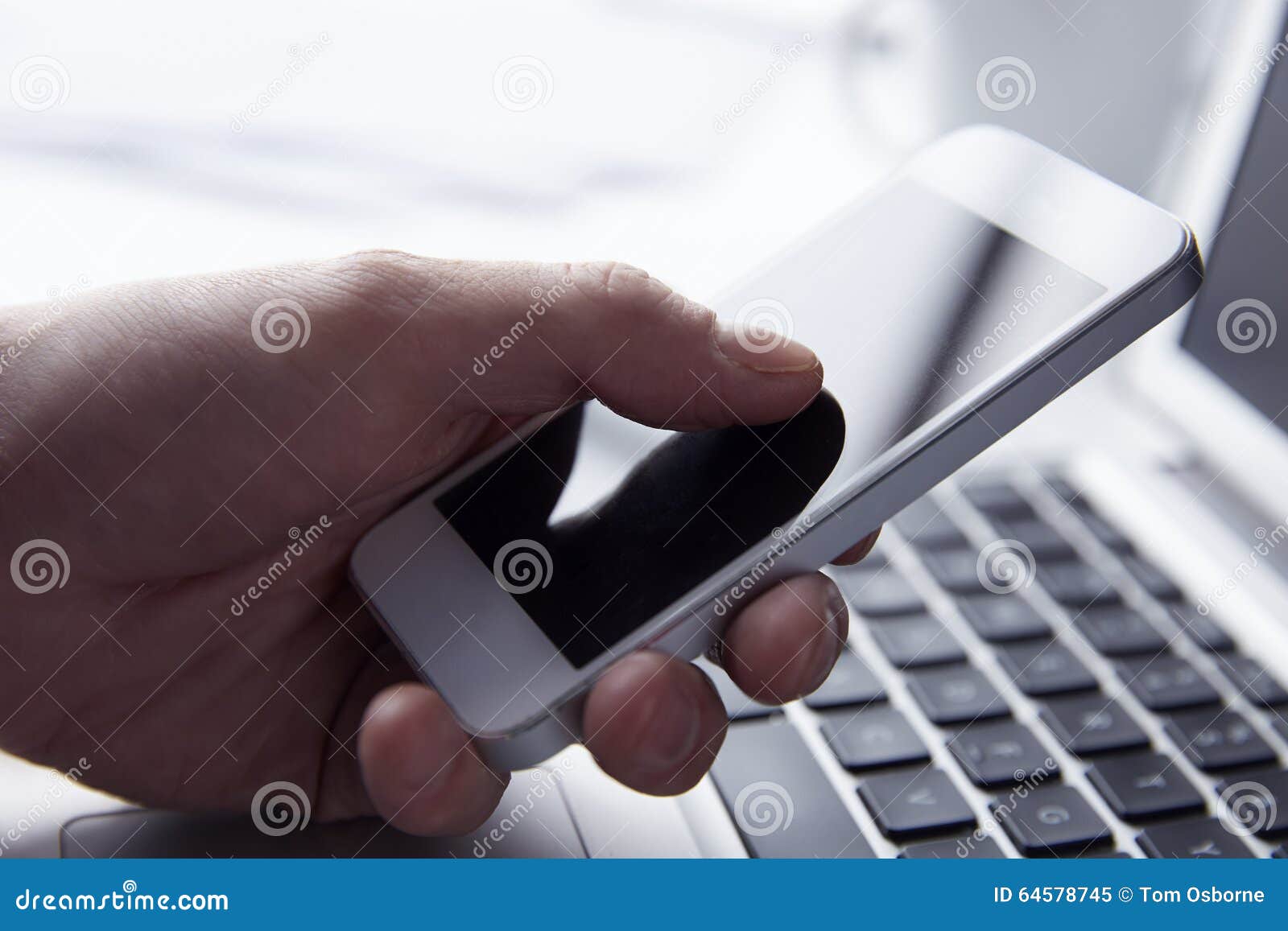 Person Using Phone while Working on a Laptop Stock Image - Image of ...