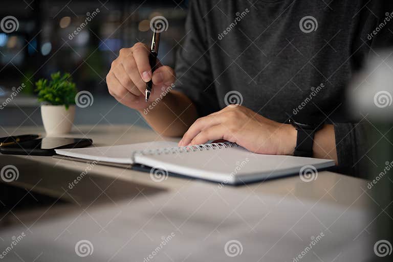 Person Writing Notes in a Notebook in an Office Setting, Capturing the ...