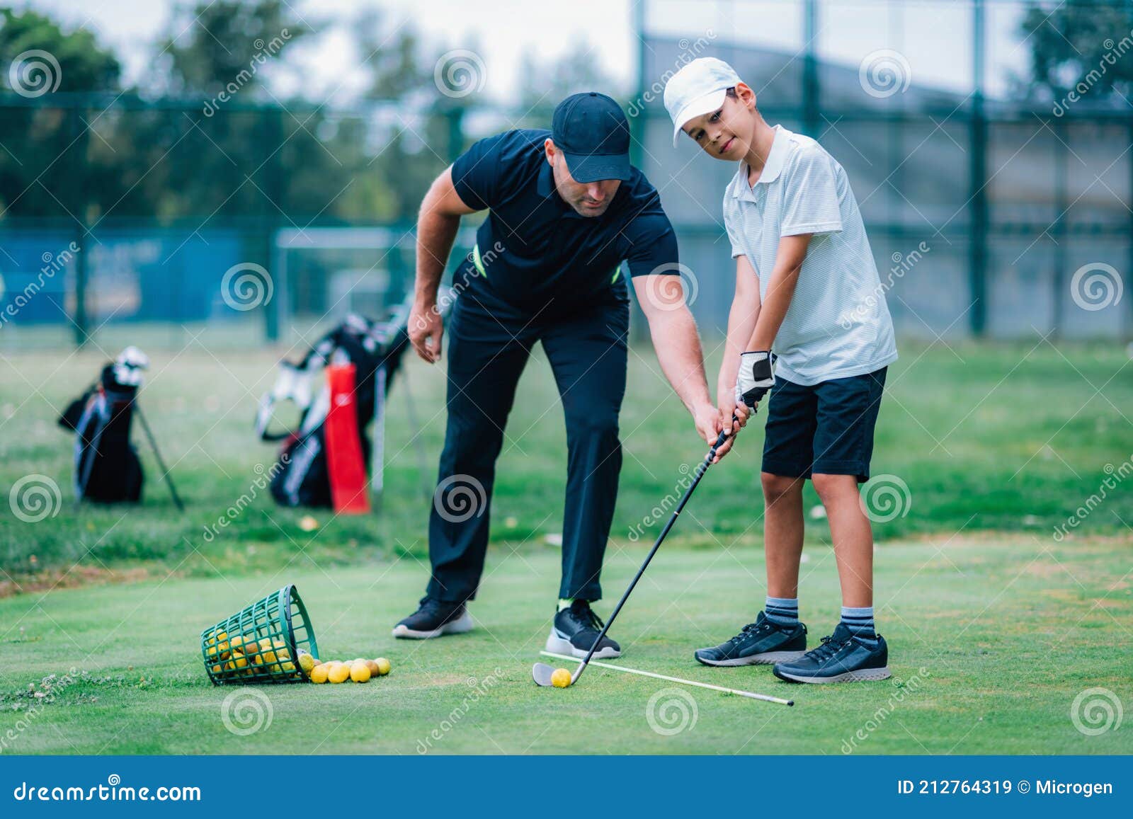 Personal Golf Lesson. Golf Instructor with Young Boy on a Golf Driving ...