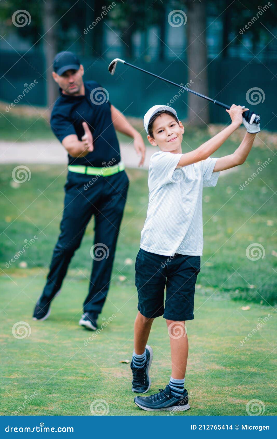 Personal Golf Lessons. Golf Instructor Adjusting Swing of a Young Boy ...
