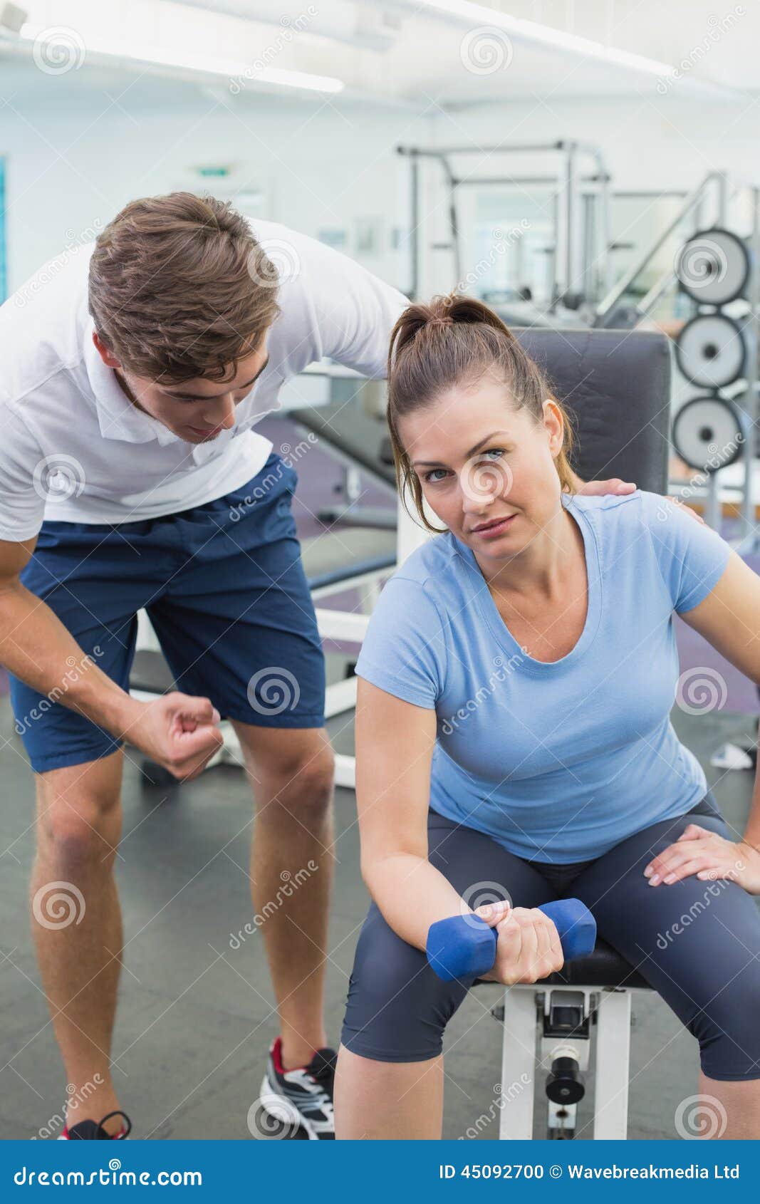 Personal Trainer Helping Client Lift Dumbbell Stock Photo - Image of ...