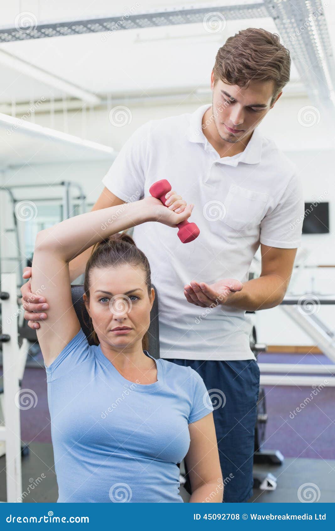 Personal Trainer Helping Client Lift Dumbbell Stock Photo - Image of ...