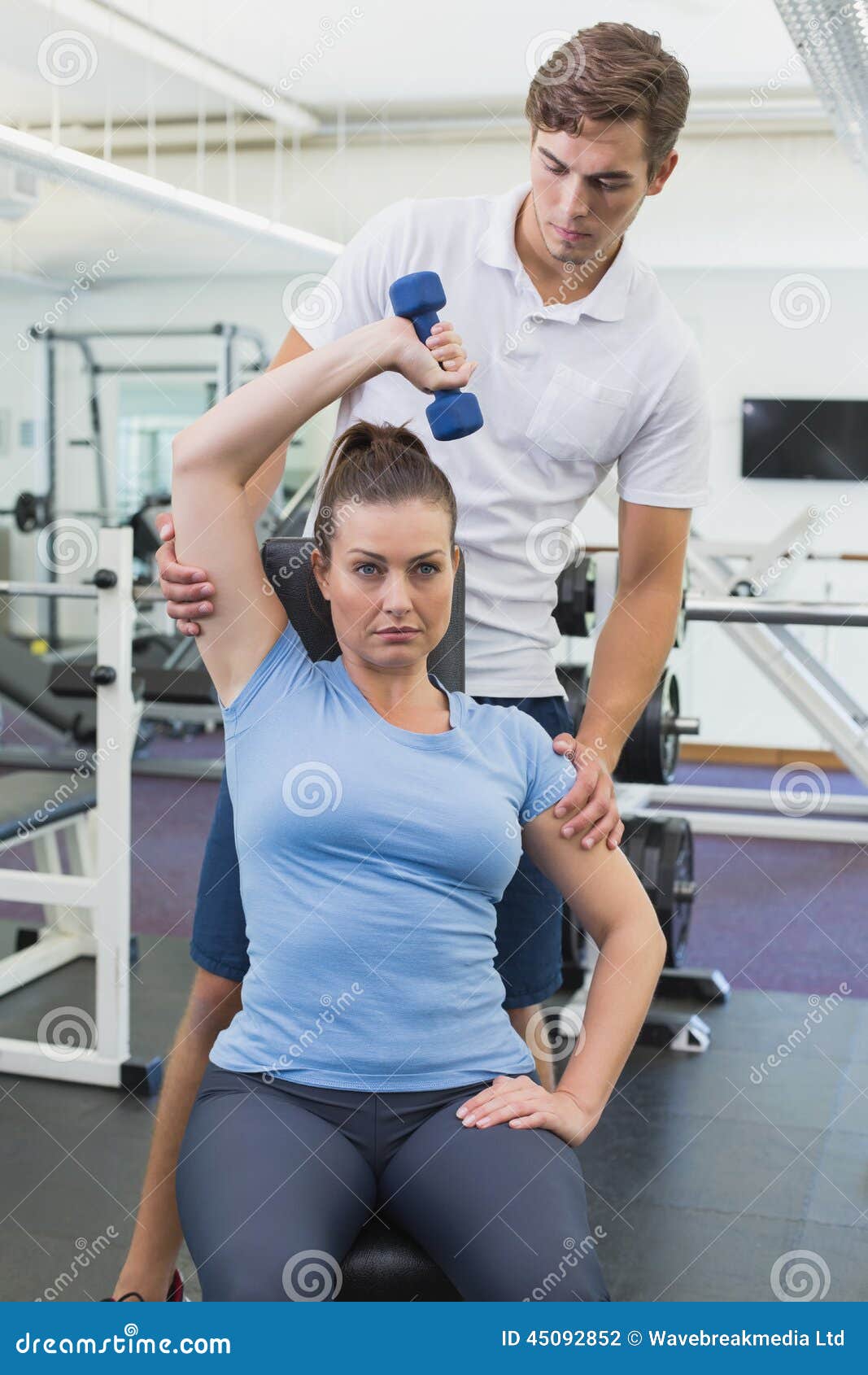 Personal Trainer Helping Client Lift Dumbbell Stock Photo - Image of ...